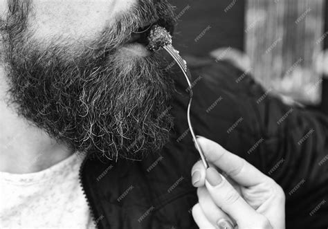 Premium Photo Male With Beard Eats Raspberry On Blurred Background