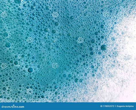 Background With White Soap Foam In Blue Turquoise Bright Water Ocean