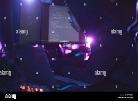 Side View At Unrecognizable Cyber Security Hacker Wearing Hood While