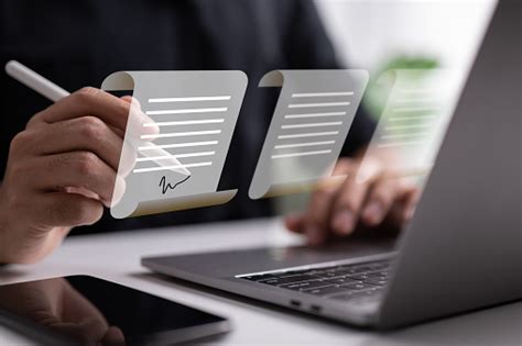 협정 계약서에 서명했습니다 전자 문서 아이콘 전자 문서 관리 온라인 문서 데이터베이스 및 종이없는 사무실의 개념이있는 랩톱 컴퓨터에서 일하는 사업가 보고서에 대한 스톡 사진