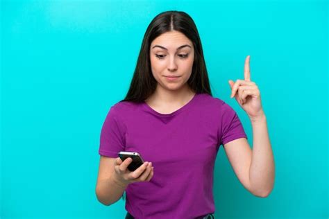 Premium Photo Young Girl Isolated On Blue Background Using Mobile