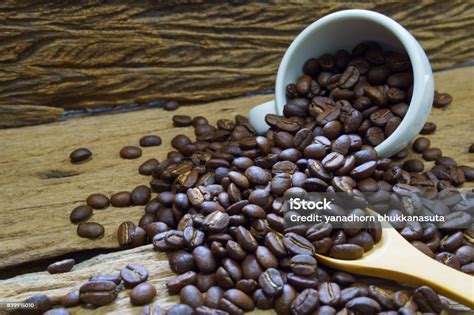 매체 또는 어두운 볶은 커피 콩 및 오래 된 나무 판자에 나무 숟가락으로 흰색 컵의 더미 커피 개념 가방에 대한 스톡 사진 및