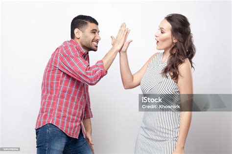 하이 파이브 빨간색 체크 무늬 셔츠에 행복 한 잘생긴 남자와 백색 줄무늬 드레스 서 및 Celebraiting 승리에 아름 다운 여자의 프로필 사이드 뷰 초상화 행복에 대한
