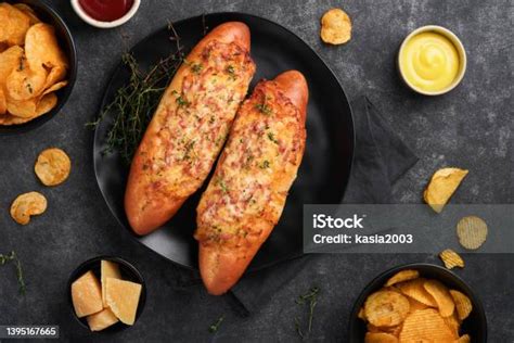 바게트 보트 양피지와 검은 색 어두운 콘크리트 배경에 햄 베이컨 야채 및 치즈가있는 바게트 빵에 뜨거운 구운 샌드위치 상단 보기 공간을 복사합니다 가공육에 대한 스톡 사진