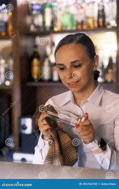 Woman Bartender Rubs The Glass In Cafe Girl Barista In Casual Clothes Smiling And Using Rag