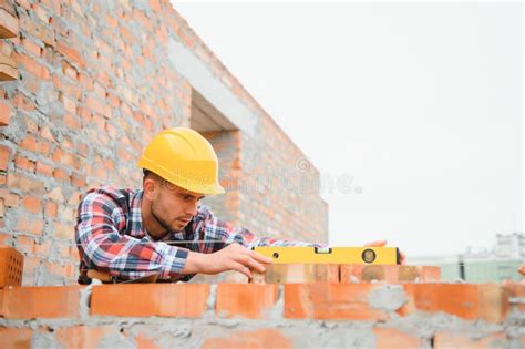 Installing Brick Wall Construction Worker In Uniform And Safety