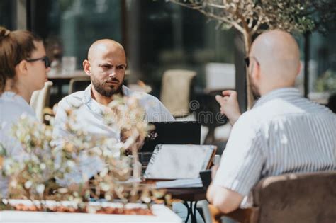 Startup Team In Business Meeting Discussing Strategies Outdoors At Cafe