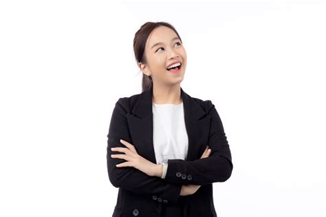 흰색 배경에 고립되어 서 있는 팔짱을 끼고 양복을 입은 아름다운 사업가 젊은 아시아 비즈니스 여성은 자신감 있는 관리자 또는