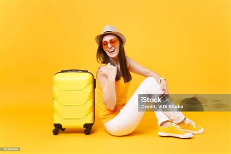여행자 관광 여자 여름 캐주얼 옷 모자 가방 노란색 오렌지 배경에 격리와 앉아 여성 승객 주말도 주에 여행을 해외 여행 공기 비행 여행 개념 Unmanned