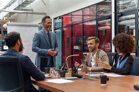 성숙한 비즈니스 코치 또는 연사는 회의에서 다양한 사업가에게 플립 차트 프리젠 테이션을합니다 업무 회의에 대한 스톡 사진 및 기타 이미지 Istock