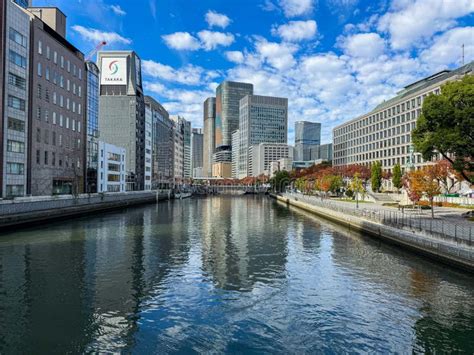 Wide View Of Modern City Buildings Along A Calm Urban River In Osaka