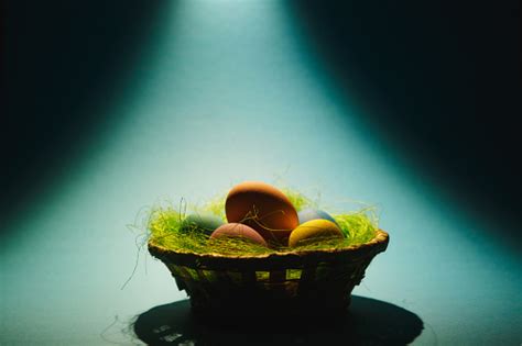 다채로운 파스텔 모노 전통적인 그린된 부활절 달걀 바구니 검은 그림자 실루엣 라이트와 어두운 파란색 배경에 녹색 잔디입니다 광고에 대 한 공간을 복사 합니다 텍스트에 대 한