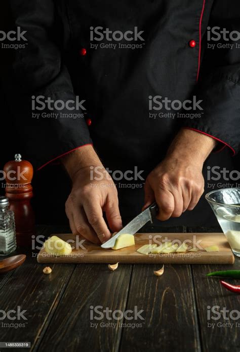 국가 요리를 준비하기 전에 요리사는 생 감자를 칼로 작은 조각으로 자른다 레스토랑 주방에서 일하는 동안 요리사 손을 클로즈업하십시오 감자 요리에 대한 스톡 사진 및 기타