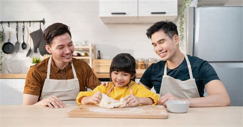 아시아의 매력적인 Lgbtq 게이 가족은 효모 반죽을 만드는 소녀 아이를 가르칩니다 잘 생긴 남자 부부는 부엌에서 작은