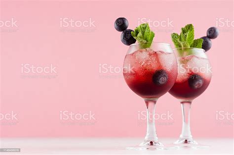 가볍고 부드러운 파스텔 핑크 색상의 우아하고 현대적인 주방 인테리어에 얼음 조각 블루 베리 그린 민트와 고급 신선한 차가운 빨간 여름 과일 칵테일 0명에 대한 스톡 사진 및