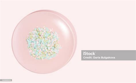 분홍색 배경에 미세 플라스틱으로 가득 찬 접시 먹이 사슬에 마이크로 플라스틱의 영향 플라스틱 오염의 개념 플레이트 및 마이크로 플라스틱의 구성 공간 복사 오염에 대한 스톡