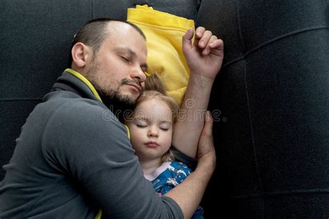 El Padre Duerme Tranquilamente Al Lado De Su Bebé Foto De Archivo