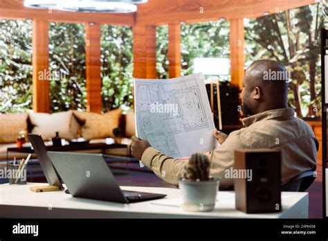 Businessman Evaluating Architectural Sketches And Planning An Office