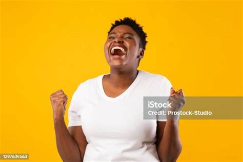 노란 배경 위에 포즈를 취하는 흔들리는 주먹을 외치는 즐거운 흑인 여성 여자에 대한 스톡 사진 및 기타 이미지 여자 한 명의 여자만 축하 Istock