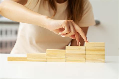 Premium Photo Woman Hand Stacking Wooden Blocks In Shape Of Staircase