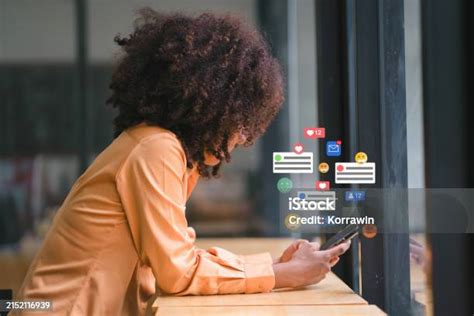 미소 짓는 아프리카계 미국인 사업가가 현대적인 작업 공간에서 스마트폰으로 소셜 미디어에 참여하고 있습니다 소셜 네트워킹에 대한 스톡 사진 및 기타 이미지 Istock