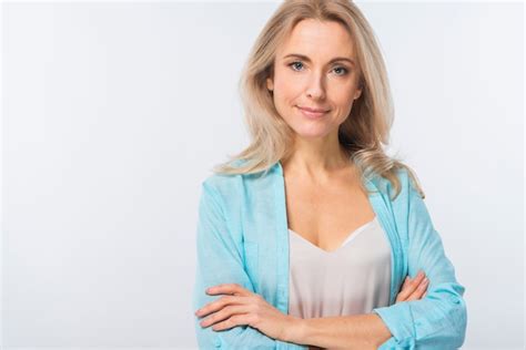 Primer De La Mujer Joven Sonriente Confiada Que Se Opone Al Contexto Blanco Foto Gratis