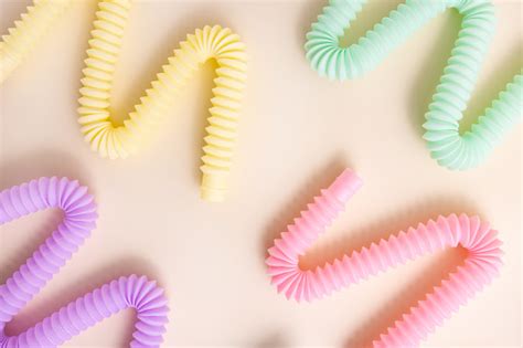 트렌디 한 어린이 장난감 파스텔 베이지 색 배경에 다채로운 팝 튜브 형태와 색상의 집합 골판지 파이프 및 안티 스트레스 휴식 Fidget 손가락 장난감 0명에 대한 스톡