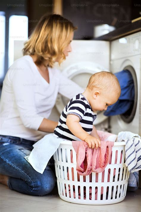집안일을 하는 어린 아들과 함께 있는 젊은 어머니 아름 다운 여자와 아기 빨래를하는 아기 세탁 바구니에 담긴 아기 사진 Unsplash의 가족 이미지