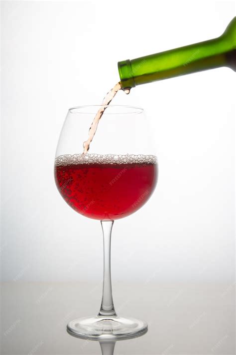Premium Photo Red Wine From A Bottle Is Poured Into A Glass On A