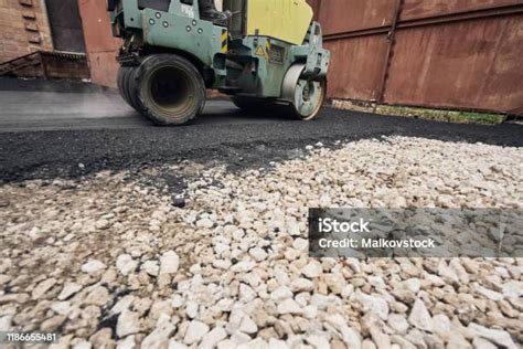 아스팔트 콤팩터는 도로 수리 작업을 수행하고 있습니다 새로운 아스팔트를 누워 대형 중장비 새로운 아스팔트 도로의 건설 거리에