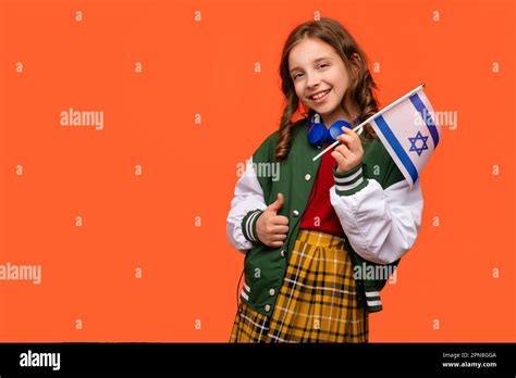 Teen Girl In School Outfit And Blue Headphones Holds Small Flag Of