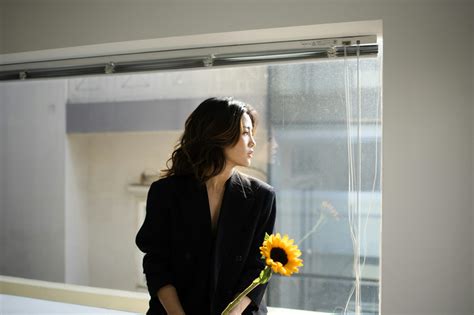 해바라기를 손에 들고 창가에 서 있는 여자 사진 Unsplash의 무료 초상 이미지