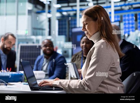 Photovoltaics Factory Management Team Analyzing Data Using Laptop