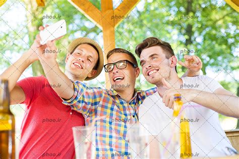 عکس با کیفیت سه دوست شاد در حال گرفتن عکس سلفی با گوشی عکس با کیفیت و