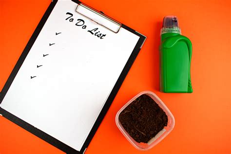 목록을 수행합니다 흰색 종이가 있는 메모장 주황색 배경에 녹색 비료 옆에 있습니다 원예 개념 공간을 복사합니다 플랫 레이 0명에 대한 스톡 사진 및 기타 이미지 Istock