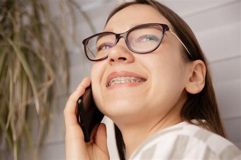 Premium Photo Young Woman With Braces In Glasses Call And Talk On