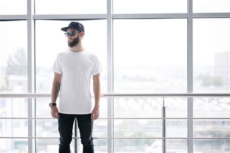흰색 빈 티셔츠와 캐주얼 한 도시 스타일의 로고 또는 디자인을위한 공간이있는 야구 모자를 입은 수염이있는 힙스터 잘 생긴 남성 모델 공란에 대한 스톡 사진 및 기타 이미지