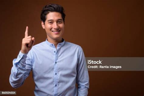 배경색에 대 한 파란색 셔츠를 입고 젊은 다민족 잘생긴 사업가의 스튜디오 샷 20 29세에 대한 스톡 사진 및 기타 이미지 20 29세 25 29세 가리키기 Istock