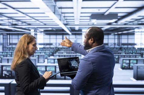 team of technicians in data center using laptop to visualize ai stock