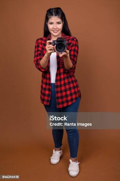 배경색에 대 한 카메라와 함께 빨간 체크 무늬 셔츠를 입고 젊은 아름 다운 아시아 여자의 스튜디오 샷 20 29세에 대한 스톡 사진 및 기타 이미지 Istock