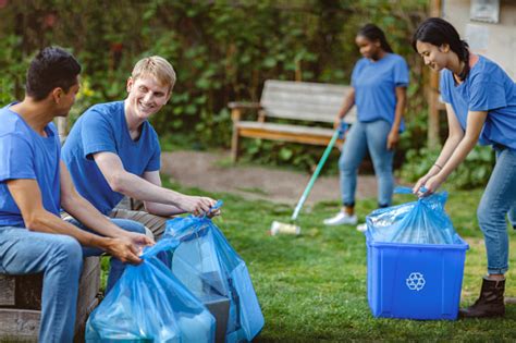 다인종 청년 남성과 젊은 여성 그룹이 쓰레기를 제거하고 물건을 재활용하기 위해 환경 정화 팀워크를 지원하기 위해 공원을 청소하기 위해 함께 자원 봉사합니다 계획에 대한 스톡
