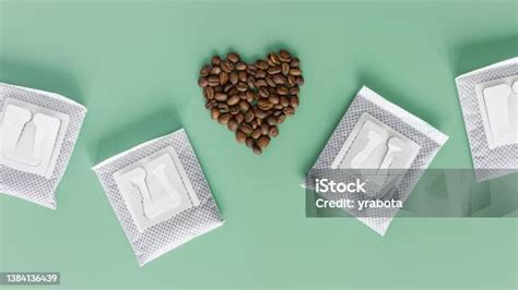 커피 원두에서 드립 커피 가방과 심장 컵양조를위한 분쇄 커피 종이 가방 드립 커피 필터 민트 색상 배경 상단 보기 최소한의 평평한 평지 파스텔 색상으로 포장 가루로 빻은에