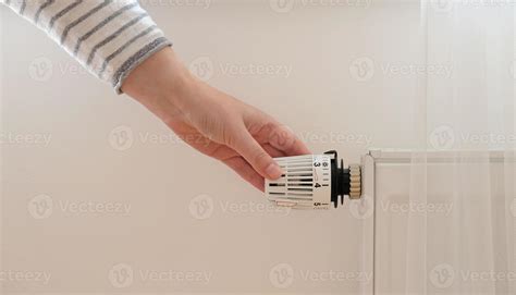 Woman Regulates Temperature At Home With The Heating Thermostat To Save Energy Close Up With