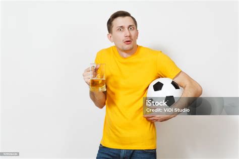 슬픈 화가 영 Bewildered 유럽 남자 팬 또는 노란색 유니폼 보류 파인트 맥주의 얼굴에서 선수 축구 응원 좋아하는 축구 팀 흰색 배경에 고립 된 공 스포츠 놀이