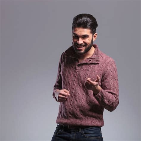 تصویری کامل از یک مرد مد جوان که در حالی که ریش خود را می خاراند و یک