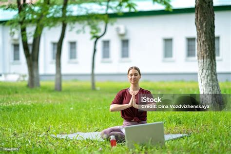 확대 축소 또는 스카이프를 통해 가이드 또는 온라인 트레이너 지침에 따라 야외에서 스포츠를하는 소녀 18 19세에 대한 스톡