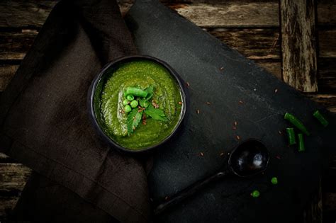 녹색 브로콜리 수프 회색 스탠드 및 나무 배경 소박한 스타일입니다 간단 하 고 영양가 있는 채식 음식입니다 씨앗으로 장식 리넨