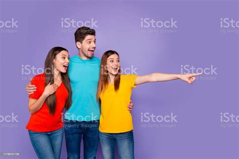 보라색 라일락 배경을 통해 고립 된 기대 멀리 가리키는 화려한 티셔츠 데님을 입고 멋진 사랑스러운 쾌활한 쾌활한 기쁜 남자의 초상화 3 명에 대한 스톡 사진 및 기타 이미지