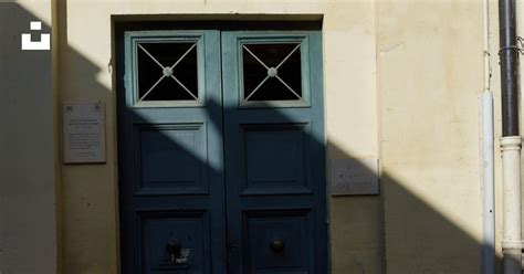 높은 건물 옆에 있는 커다란 파란색 문 사진 Unsplash의 무료 프랑스 이미지
