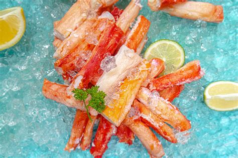 게 고기와 신체 부위 촉수 무릎 큐브 얼음에 푸른 해양 배경 레몬과 라임 의 조각은 녹색 빛 상단 측면보기 주위에 주위에 둥근 슬라이스 갈고리 발톱에 대한 스톡 사진 및